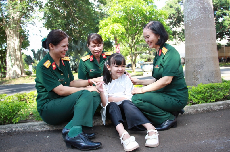 Những người mẹ áo lính chuyện trò, vui đùa cùng con gái nuôi Lê Uyên Thảo.